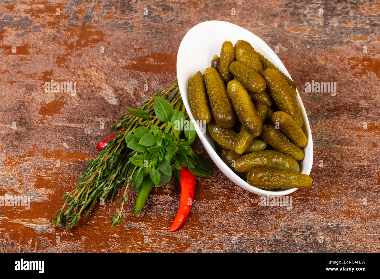 Pickled small cucumbers in the bowl served herbs Stock Photo - Alamy