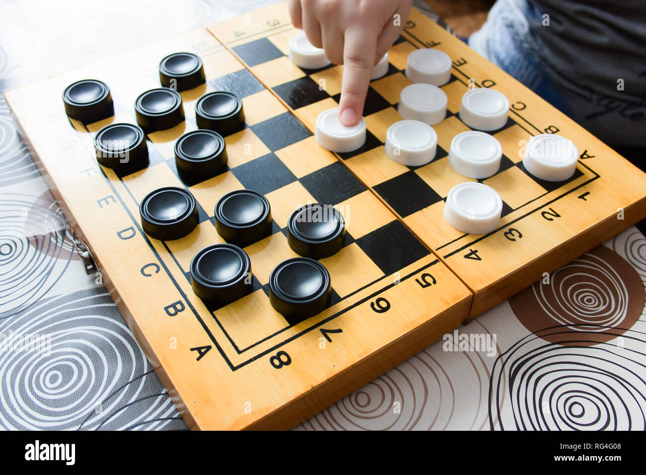 unrecognizable woman and kid playing checkers at home, closeup of a ...