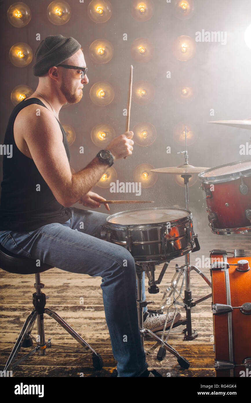 handsome fashion man learning to play drums Stock Photo - Alamy