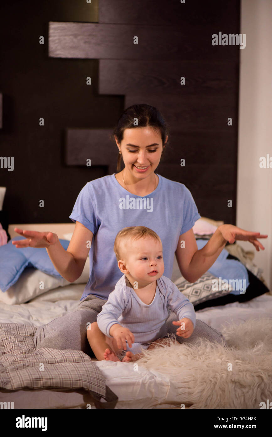 Mother with her cute little son playing on bed Stock Photo - Alamy
