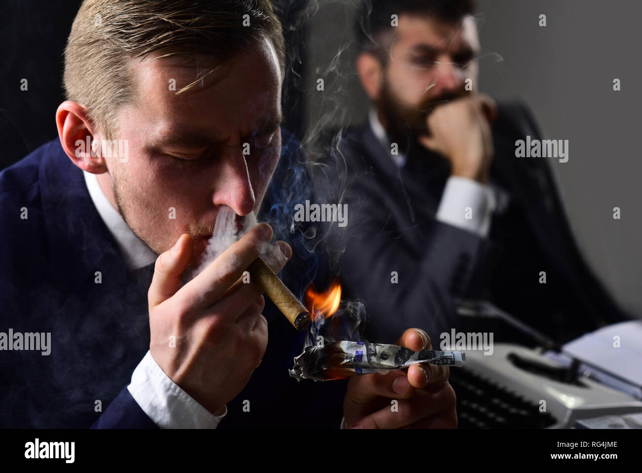 Waste of money. Man light up cigar from dollar banknote. Rich man ...