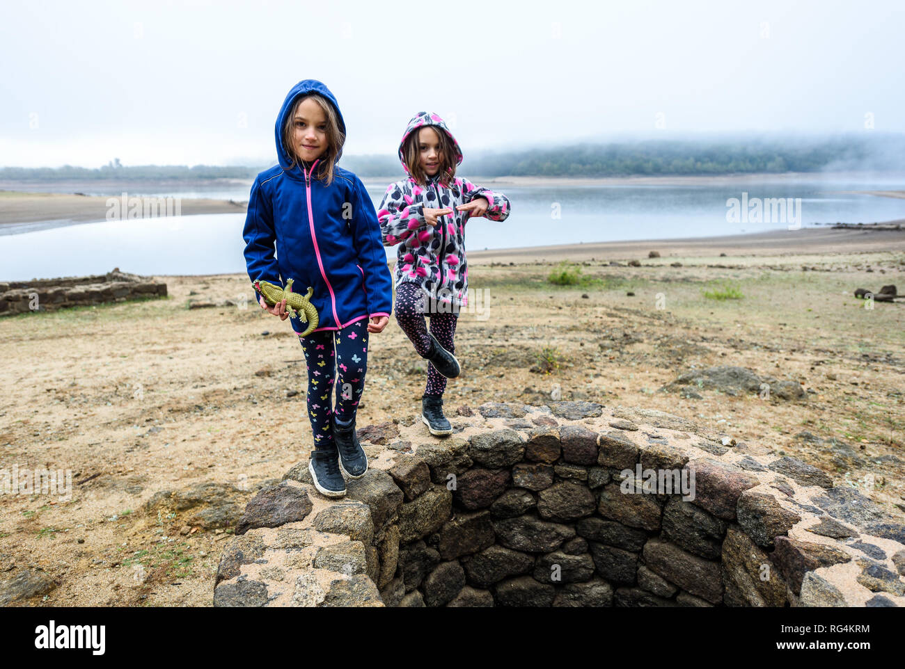 Twin girls standing on remains of ancient roman water well. Children ...