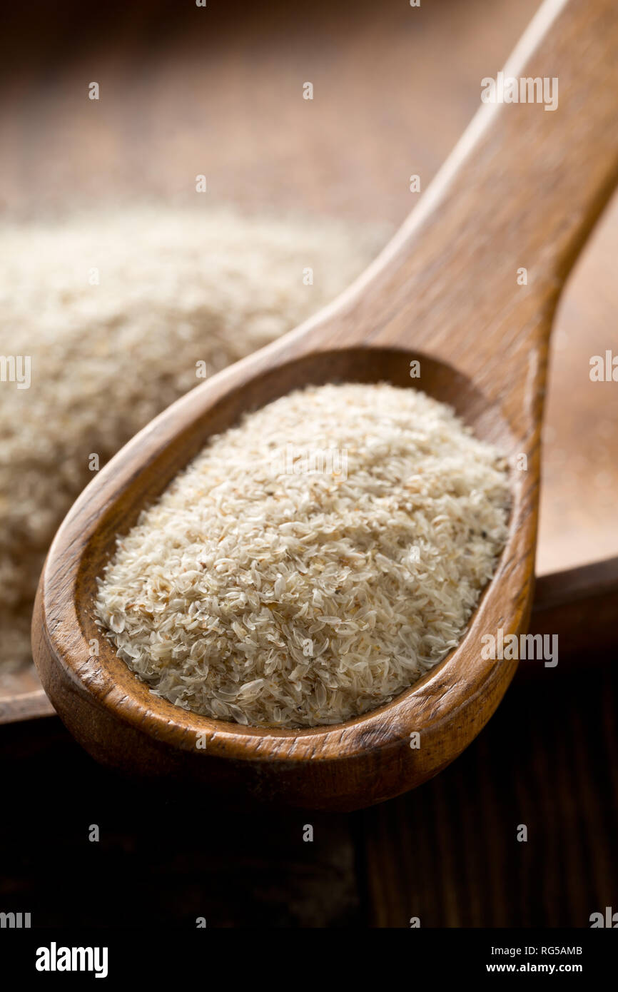 Heap of psyllium husk in wooden spoon and bowl on table. Psyllium husk ...