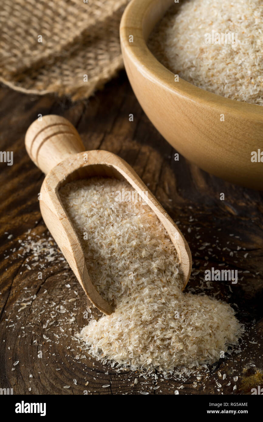 Heap of psyllium husk in wooden scoop and bowl on table. Psyllium husk ...