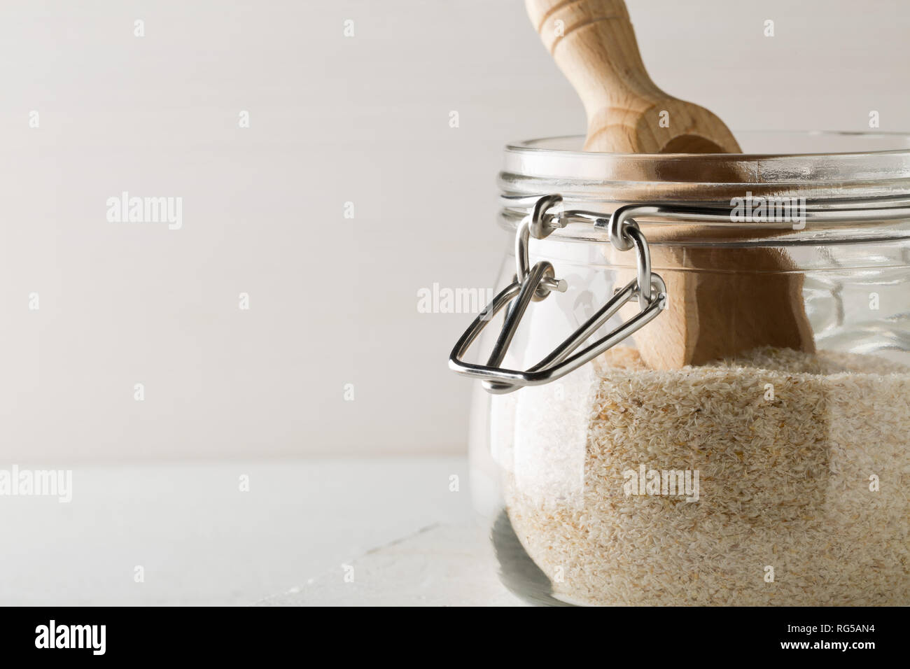 Heap of psyllium husk also called isabgol in glass jar with wooden ...