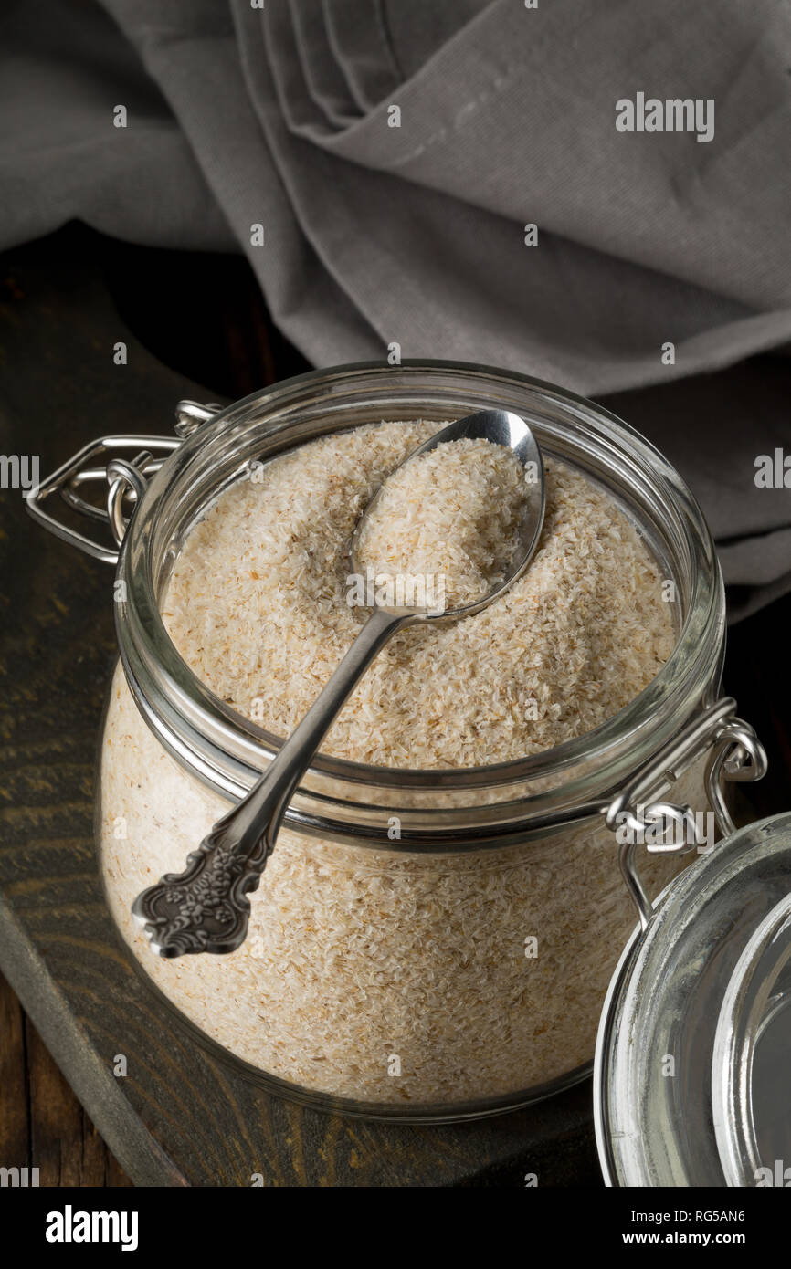 Heap of psyllium husk also called isabgol in glass jar with metal spoon ...