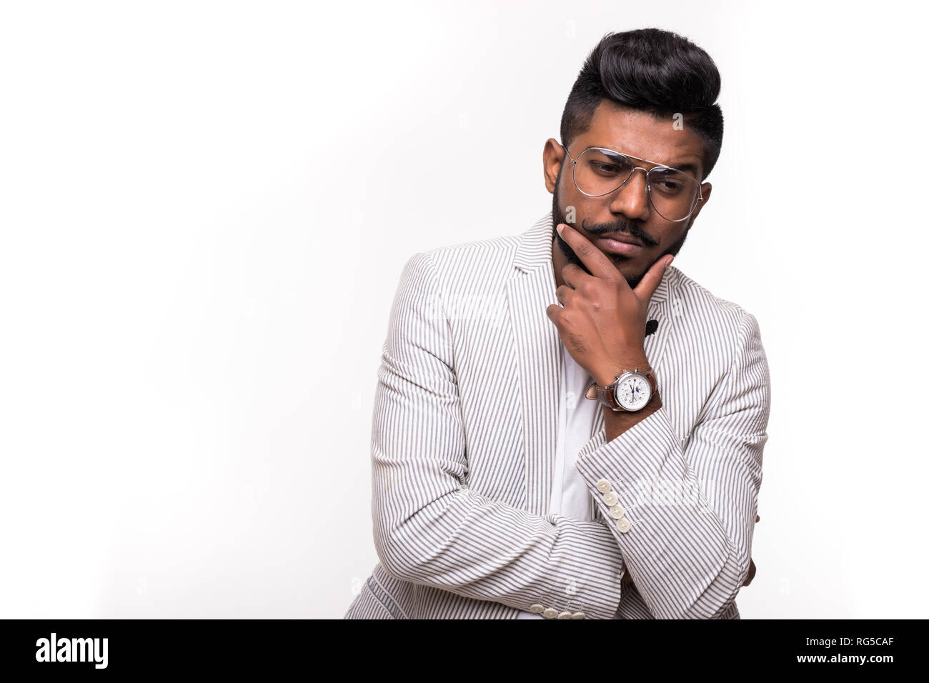 Young Indian Confused Man Scratching His Chin On White Background Stock