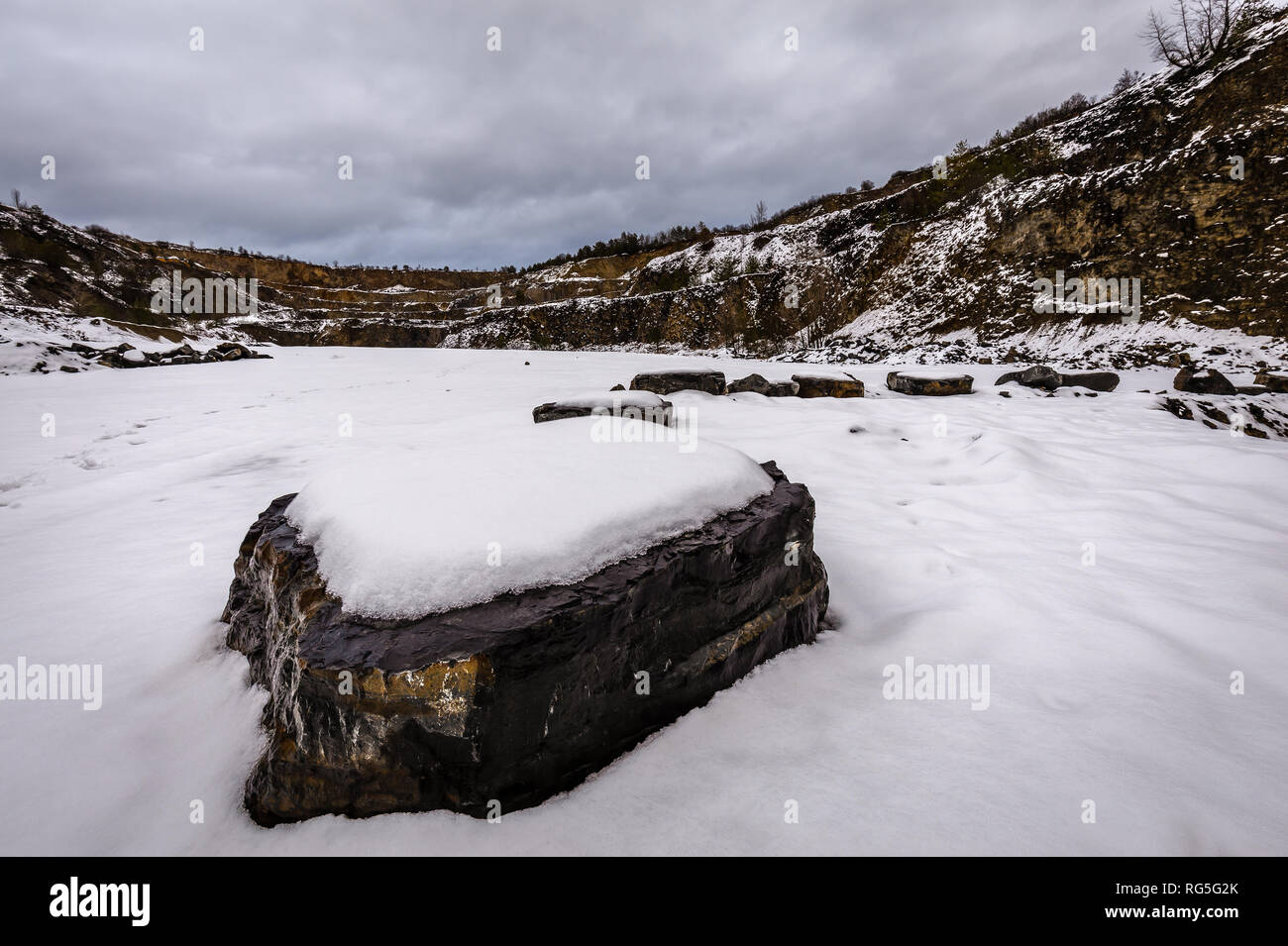 Abandoned stone quarry with big rock covered with snow near Velka ...