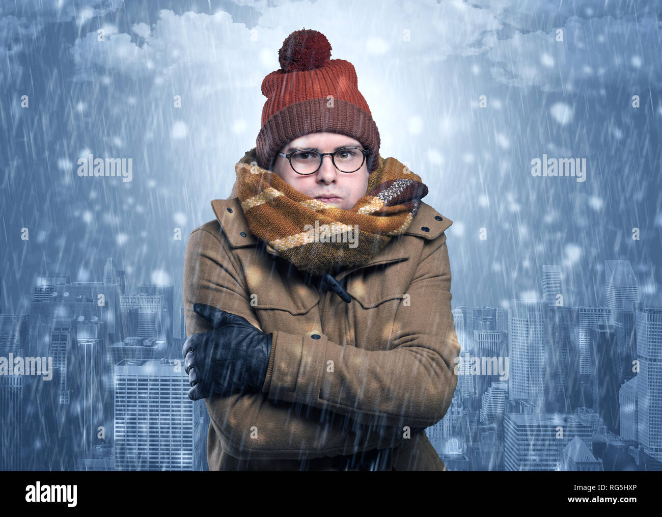 Young man freezing in warm clothing with city concept Stock Photo - Alamy