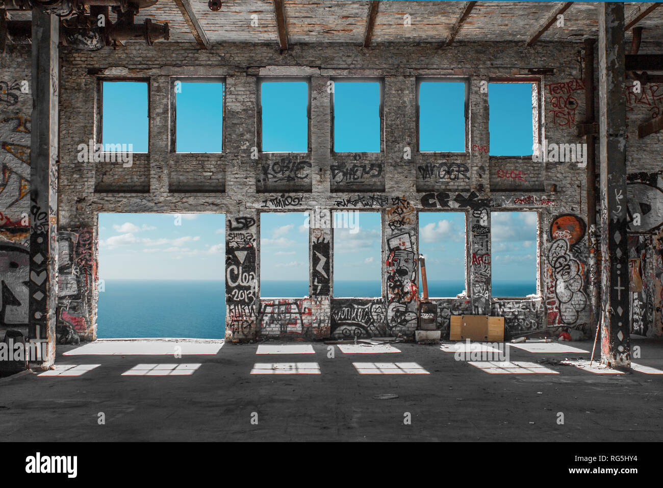 Abandoned factory ruin / warehouse loft with windows and ocean and blue ...
