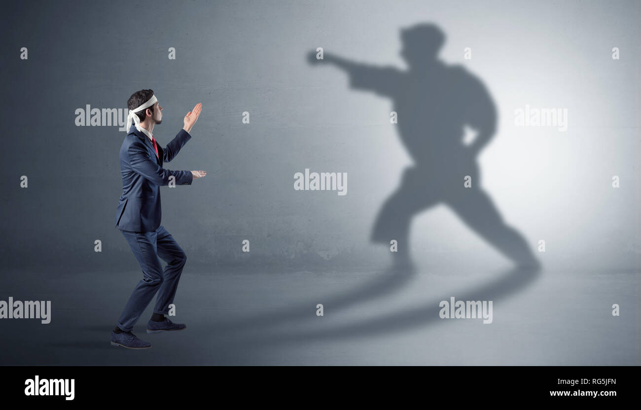 Businessman fighting with his strong karate man shadow Stock Photo - Alamy