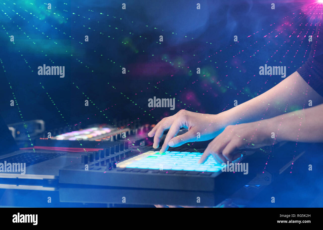 Hand mixing music on midi controller with party club colors around ...