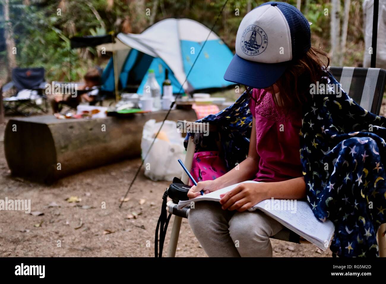 A child does homework while camping, Fern flat campsite area, Eungella ...