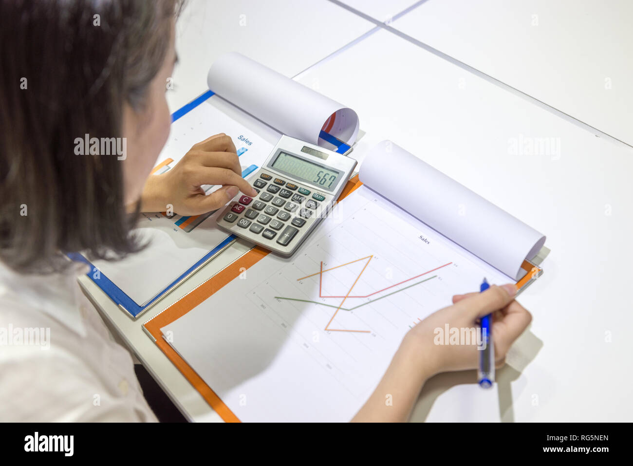 Asian office employee checking sales report at the workplace Stock ...