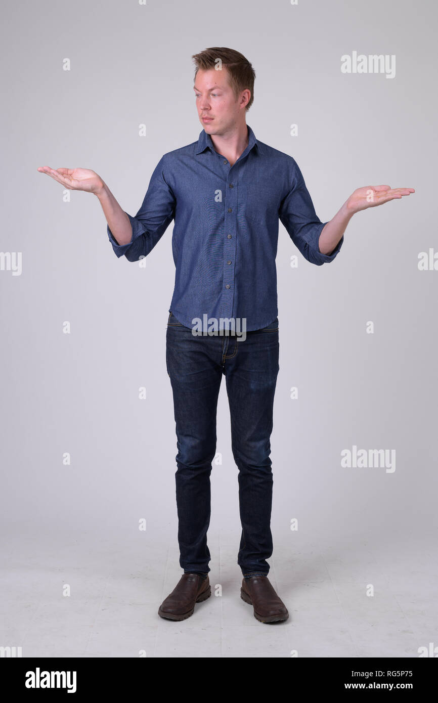 Full body shot of young handsome businessman comparing something Stock ...