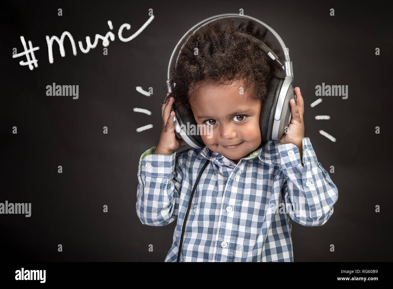 Cute little african american boy wearing earphones, listening and ...