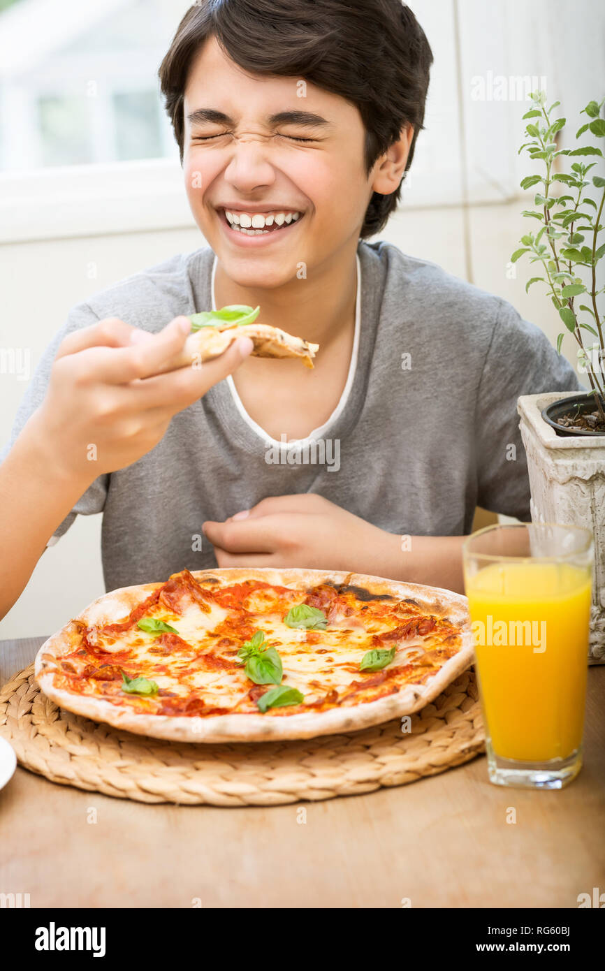 Teenager boy eating pizza hi-res stock photography and images - Alamy
