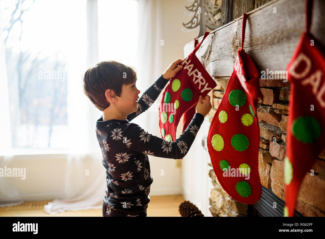 Boy hanging a Christmas stocking on a fireplace Stock Photo - Alamy