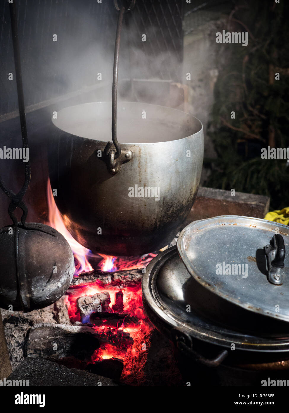 Old pot hanging from the fireplace above the wood fire Stock Photo - Alamy