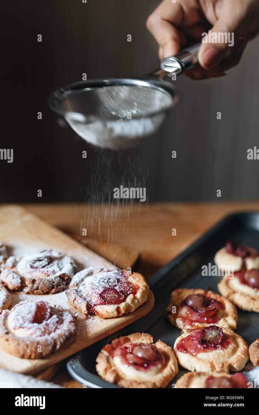 Sifting icing sugar onto burry cookies Stock Photo - Alamy