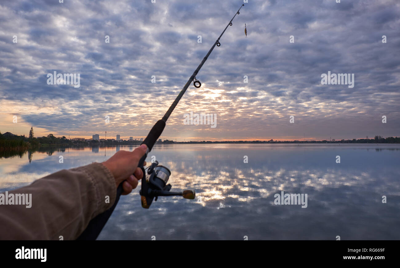 Man holding fishing rod Stock Photo - Alamy