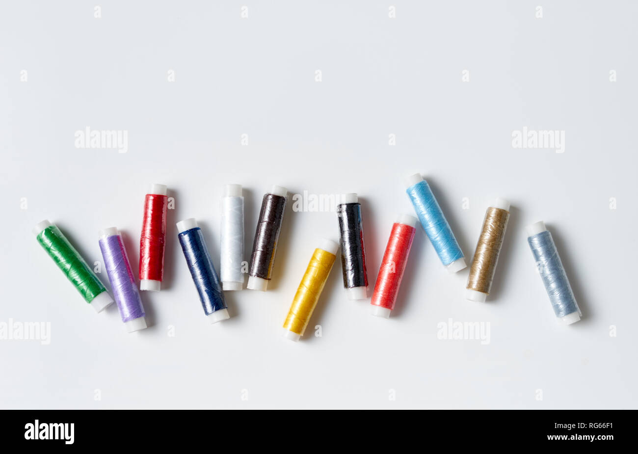 Colorful thread rolls on white background Stock Photo - Alamy