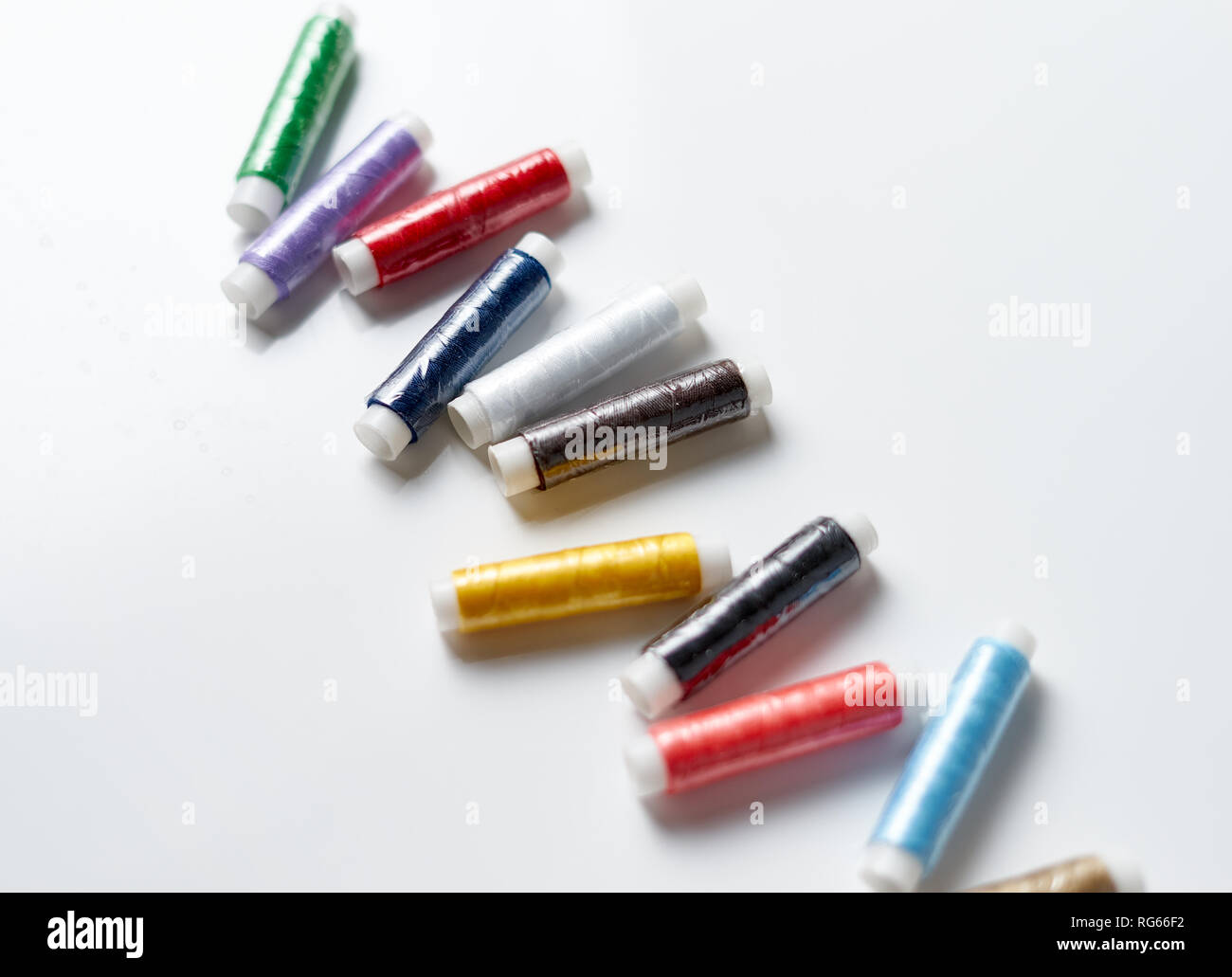 Colorful thread rolls on white background Stock Photo - Alamy