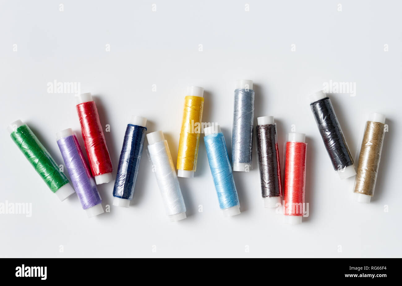 Colorful thread rolls on white background Stock Photo - Alamy