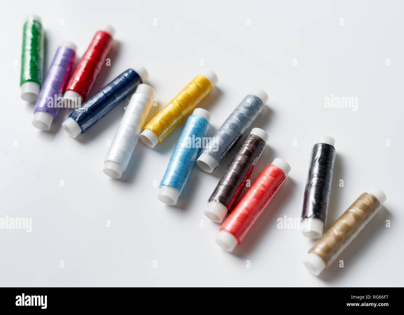 Colorful thread rolls on white background Stock Photo - Alamy