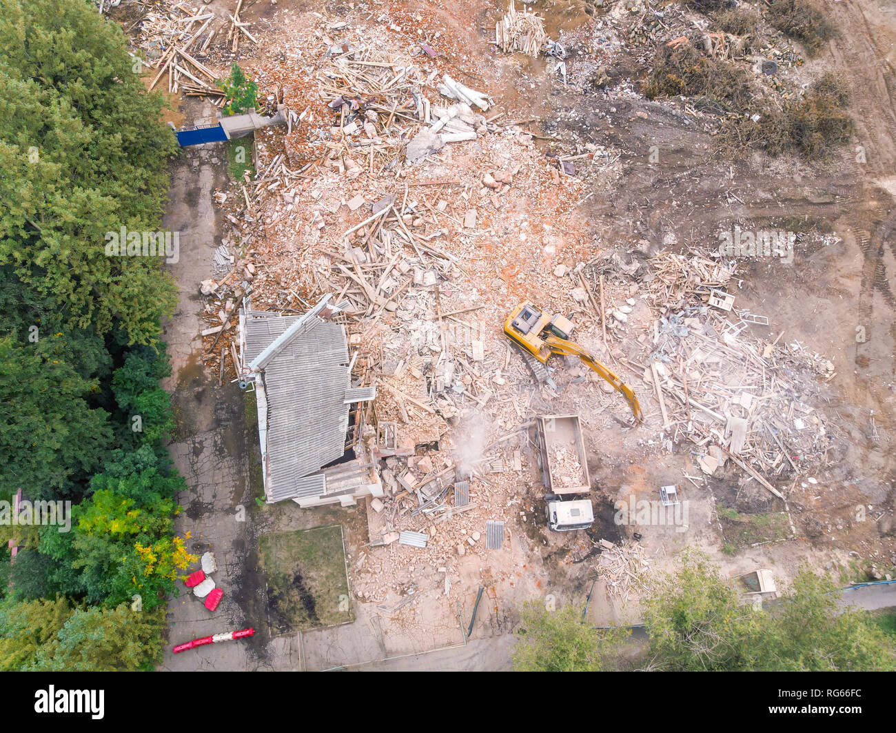 aerial top view of city demolition site. yellow excavator loading dump ...