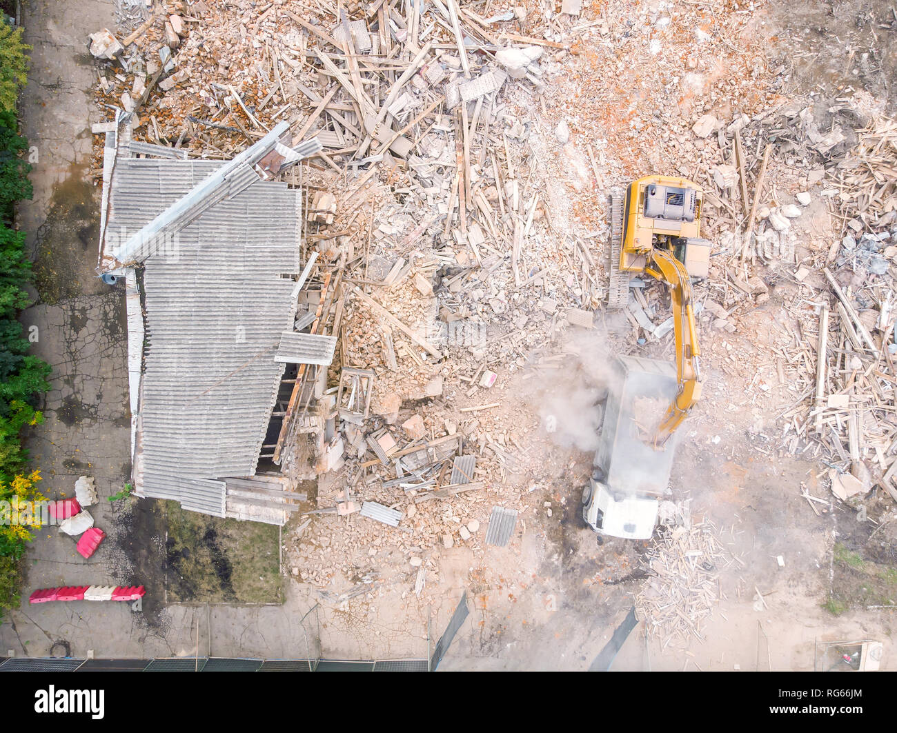 aerial top view of demolition site. backhoe is on debris from the ...