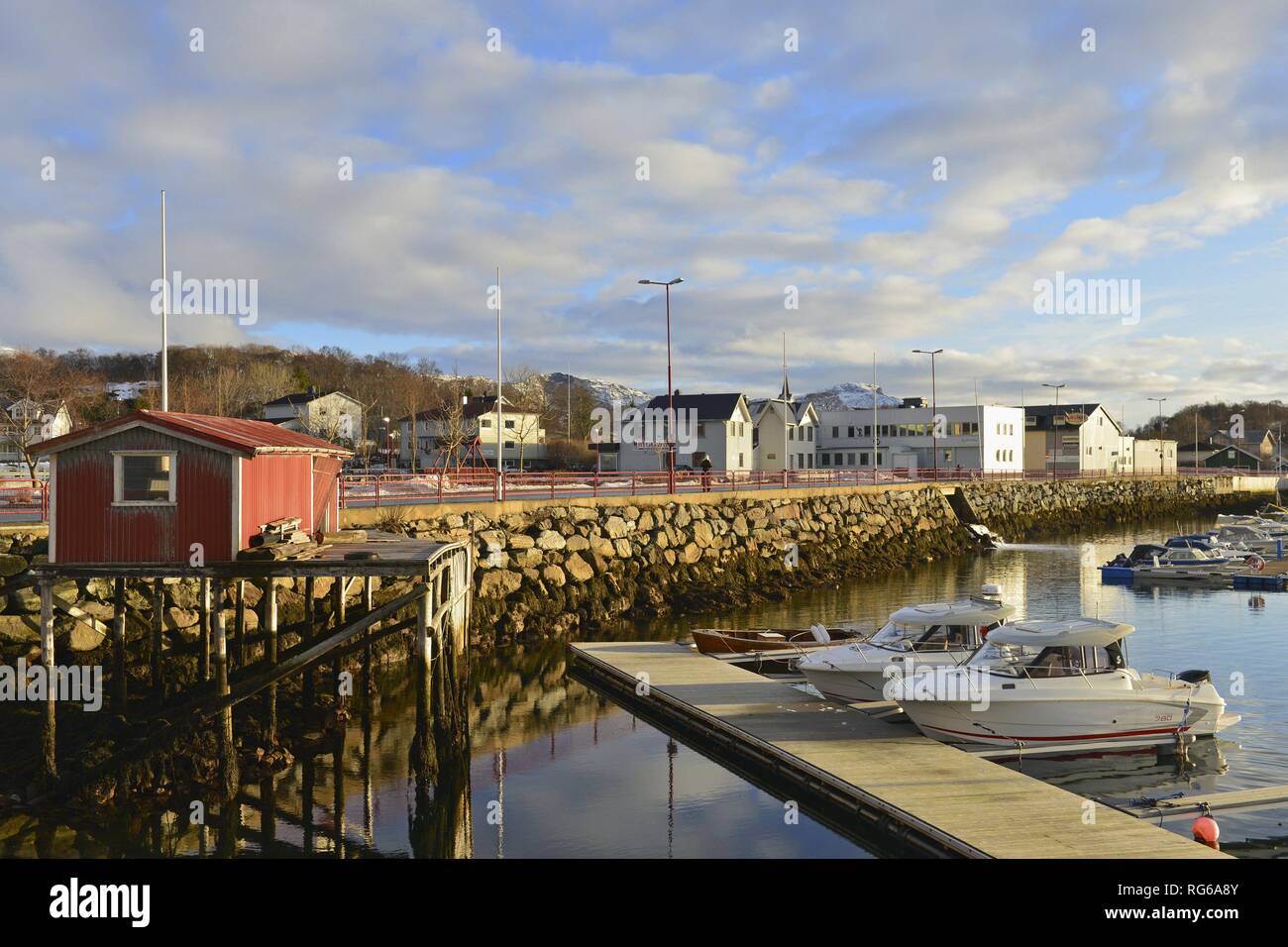Red boathouse and some recreational crafts in the smooth water of a ...