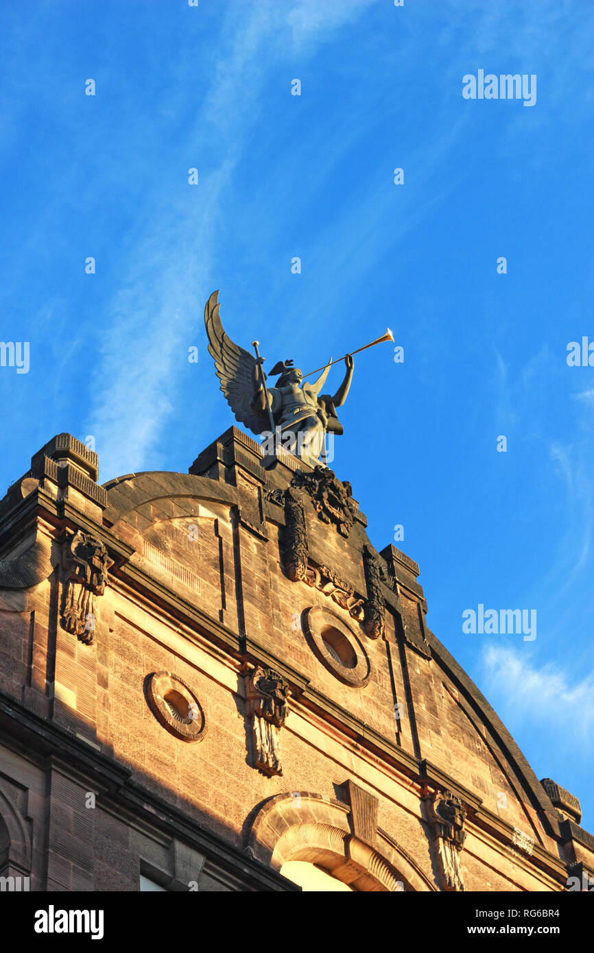 angel playing on a golden trombone on top of theh historic opera house ...