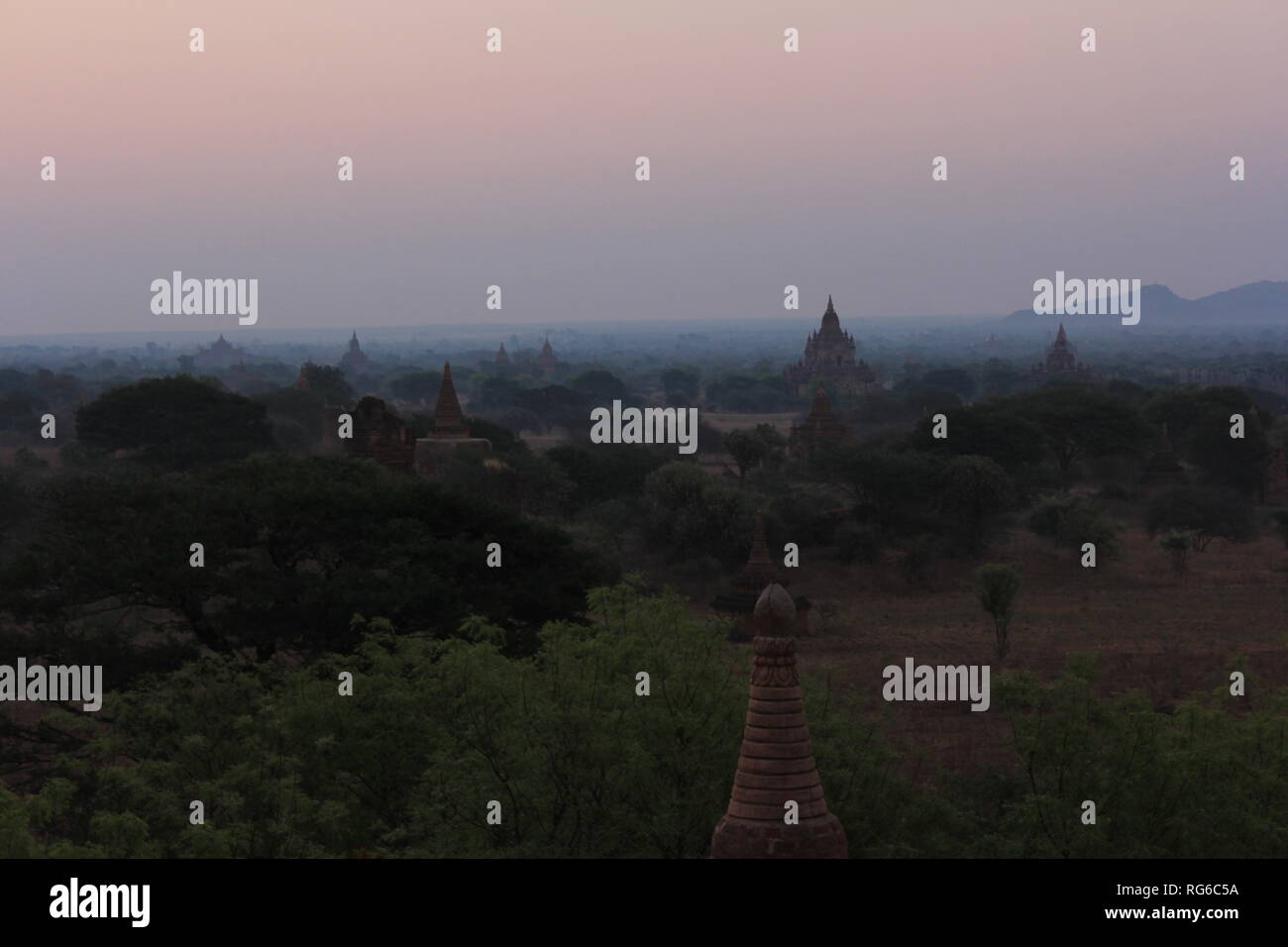Dusk landscape of Bagan temples and green bushes just before the sun ...