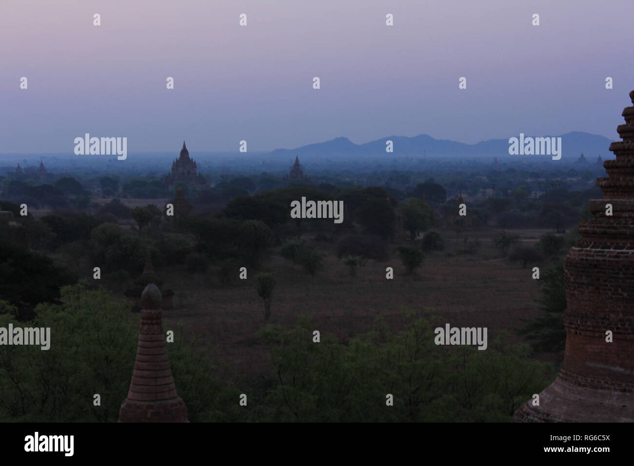 Dusk landscape of Bagan temples and green bushes just before the sun ...