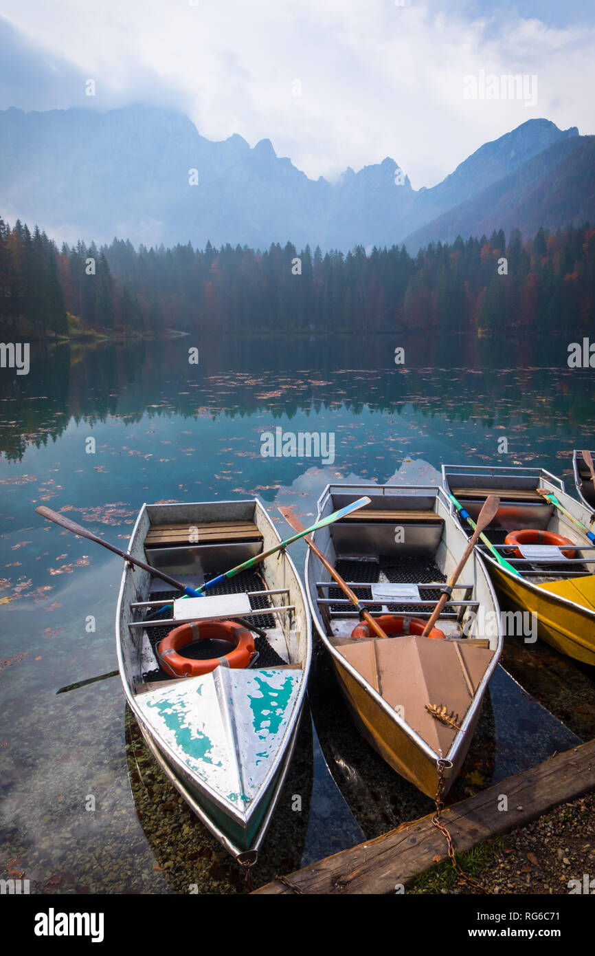 Colorful small boats in lake Laghi di Fusine near Tarvisio in Italyon a ...