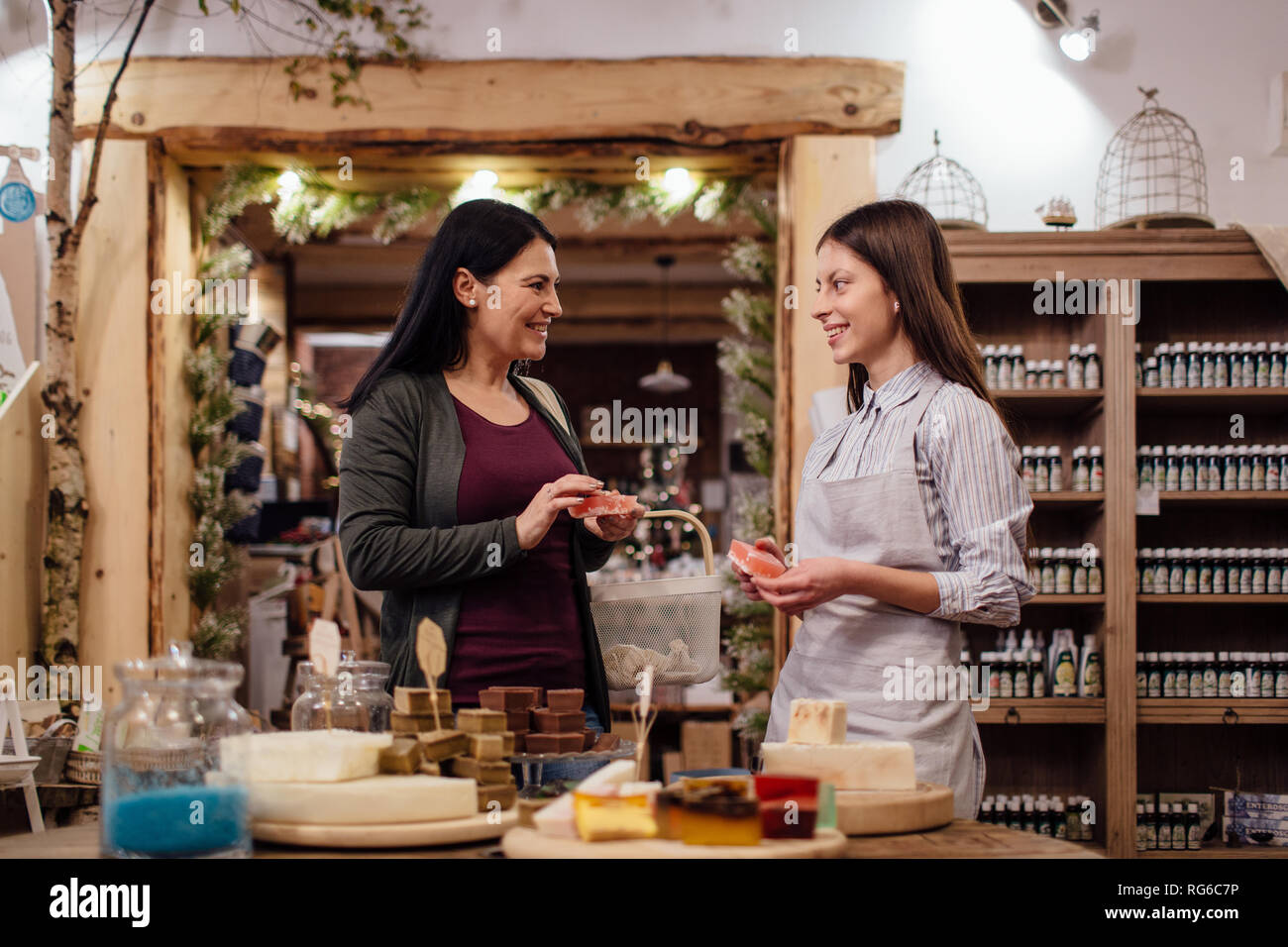 Cheerful shopkeeper helping customer in packaging free shop. Zero waste ...