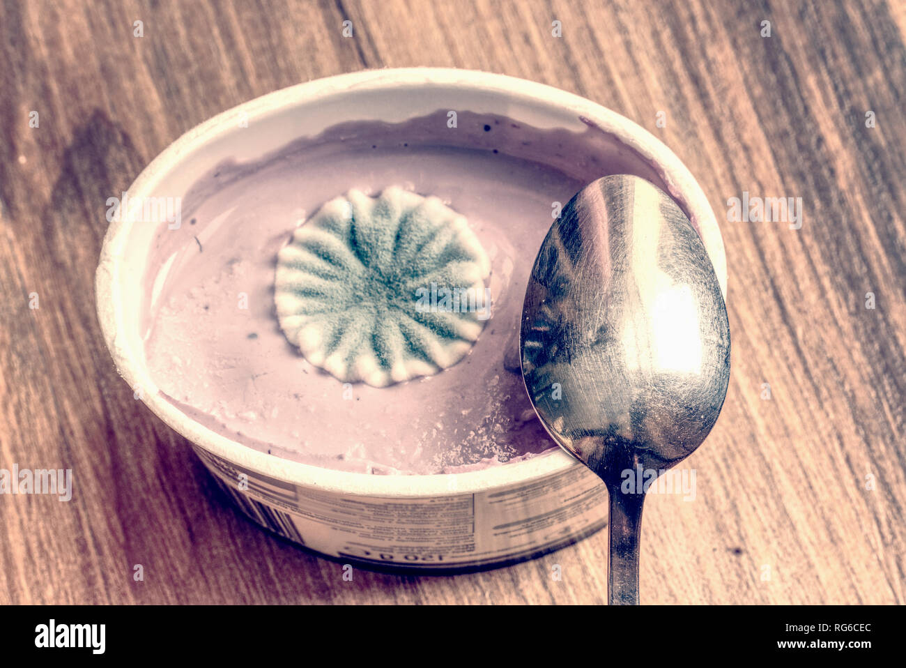 Rotten fruit yoghurt with nice colonies of mold fungi. Plastic cup ...