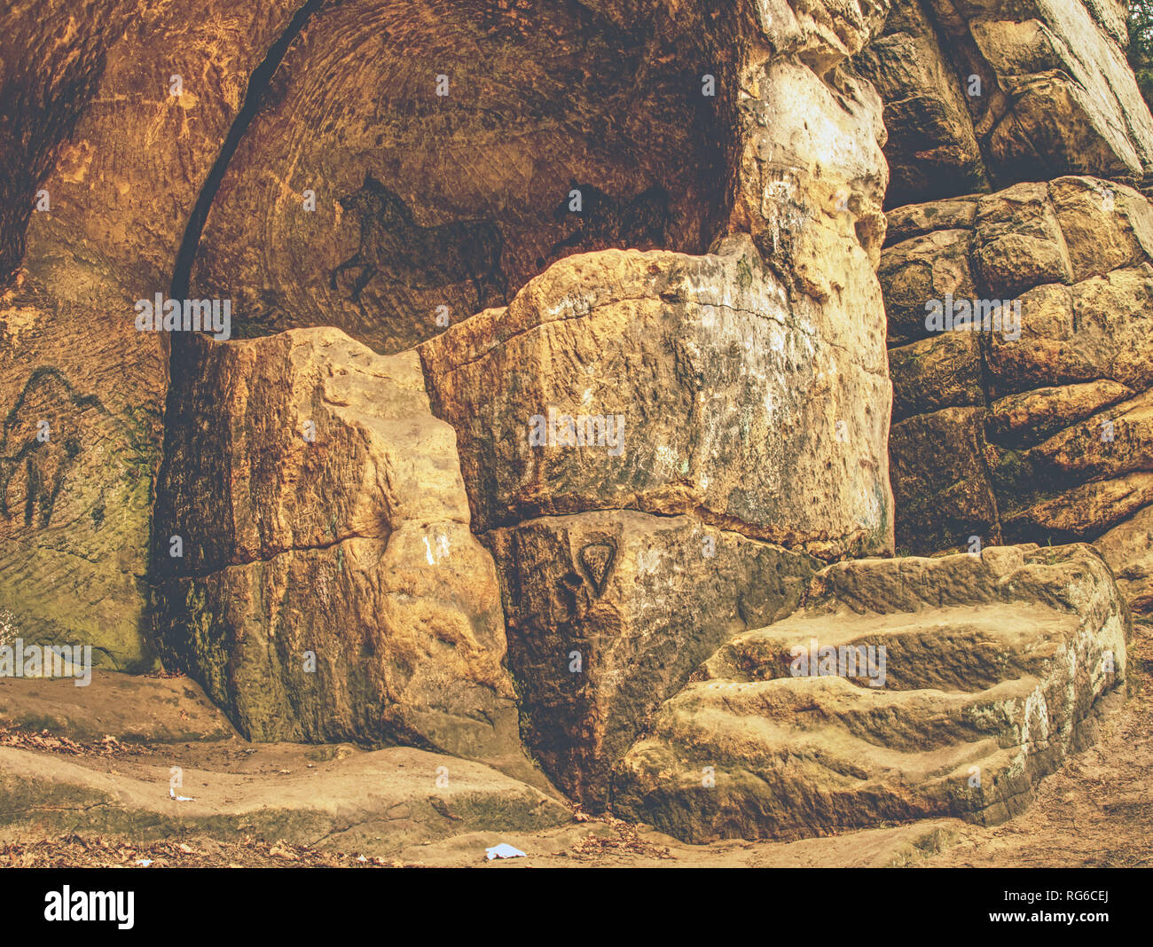 Hand-drawn cave drawings on sandstone wall. Ancient people, animals ...