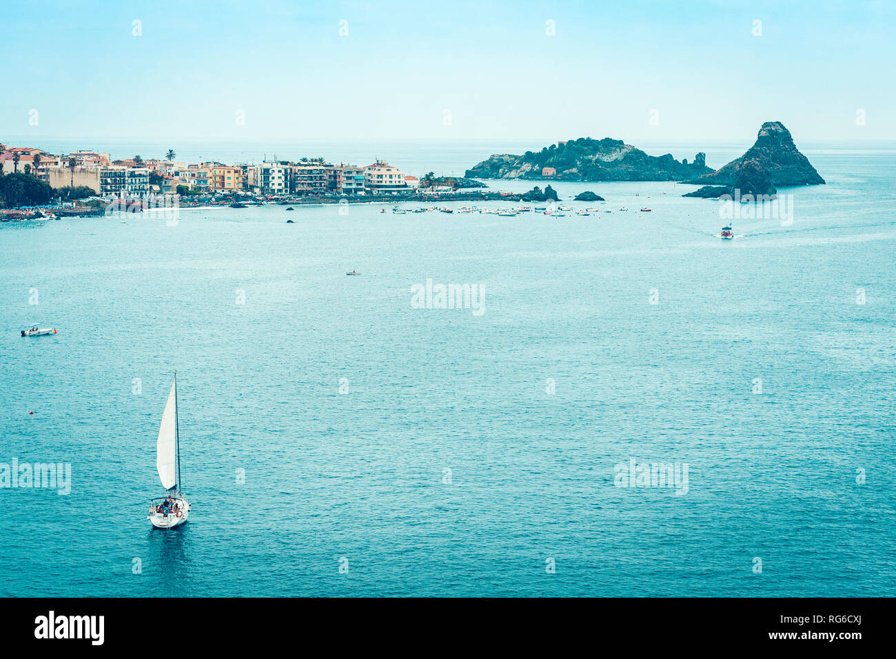 Sailboat on the background of Acitrezza rocks of the Cyclops, sea ...