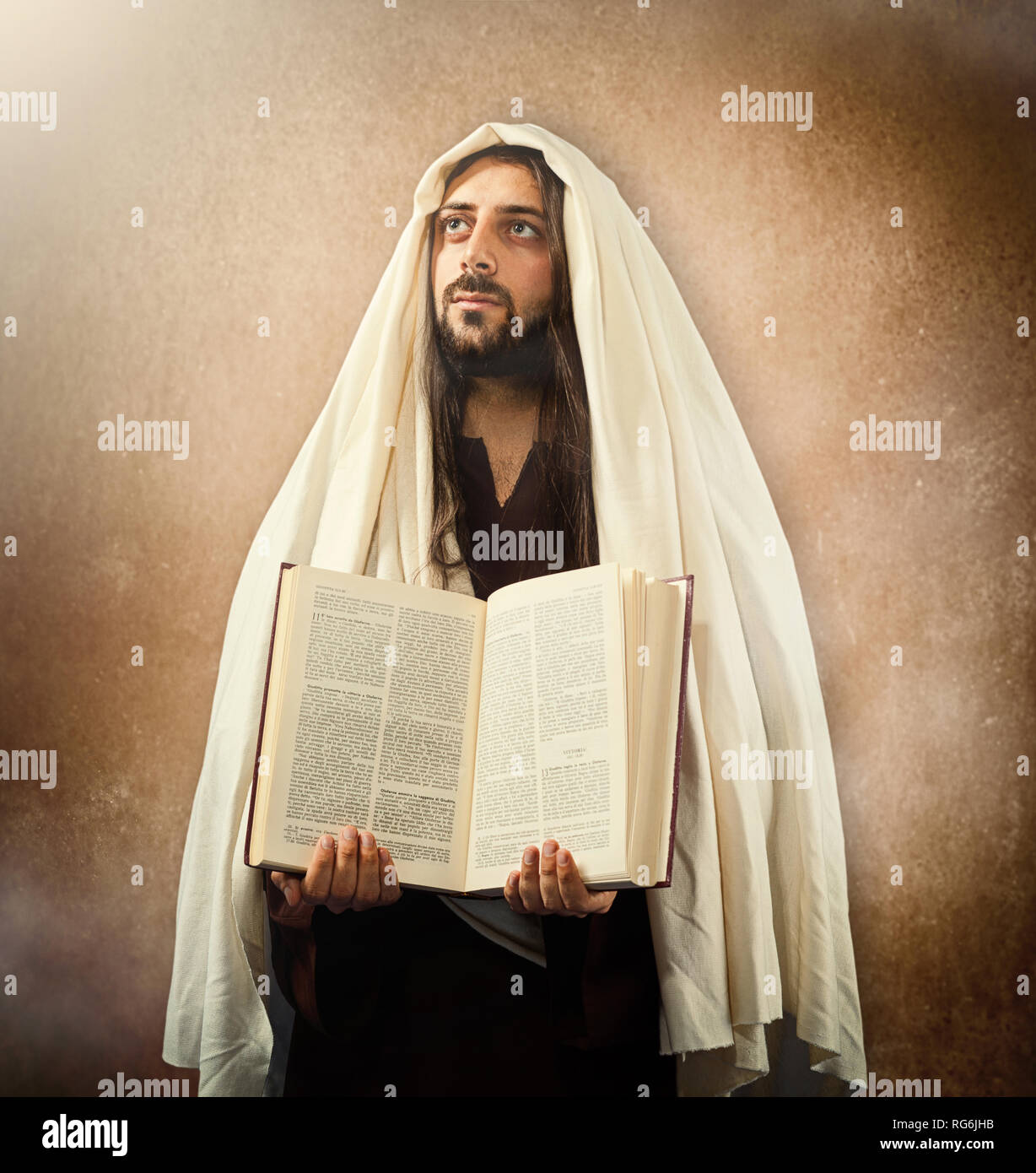 Jesus shows the holy bible on old beige background Stock Photo - Alamy