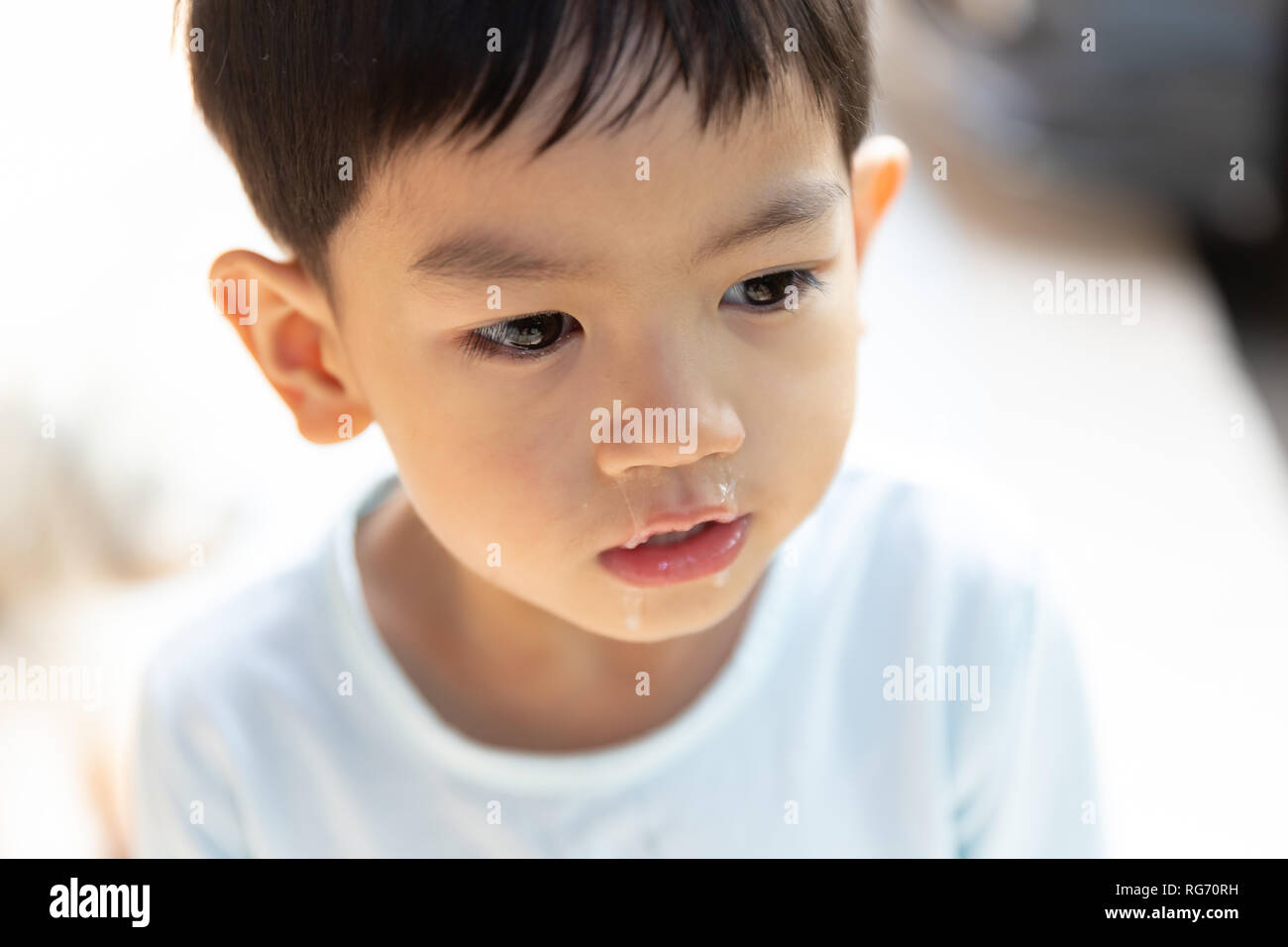 Close up mucus flowing from nose, Asian boy has a runny nose with clear ...