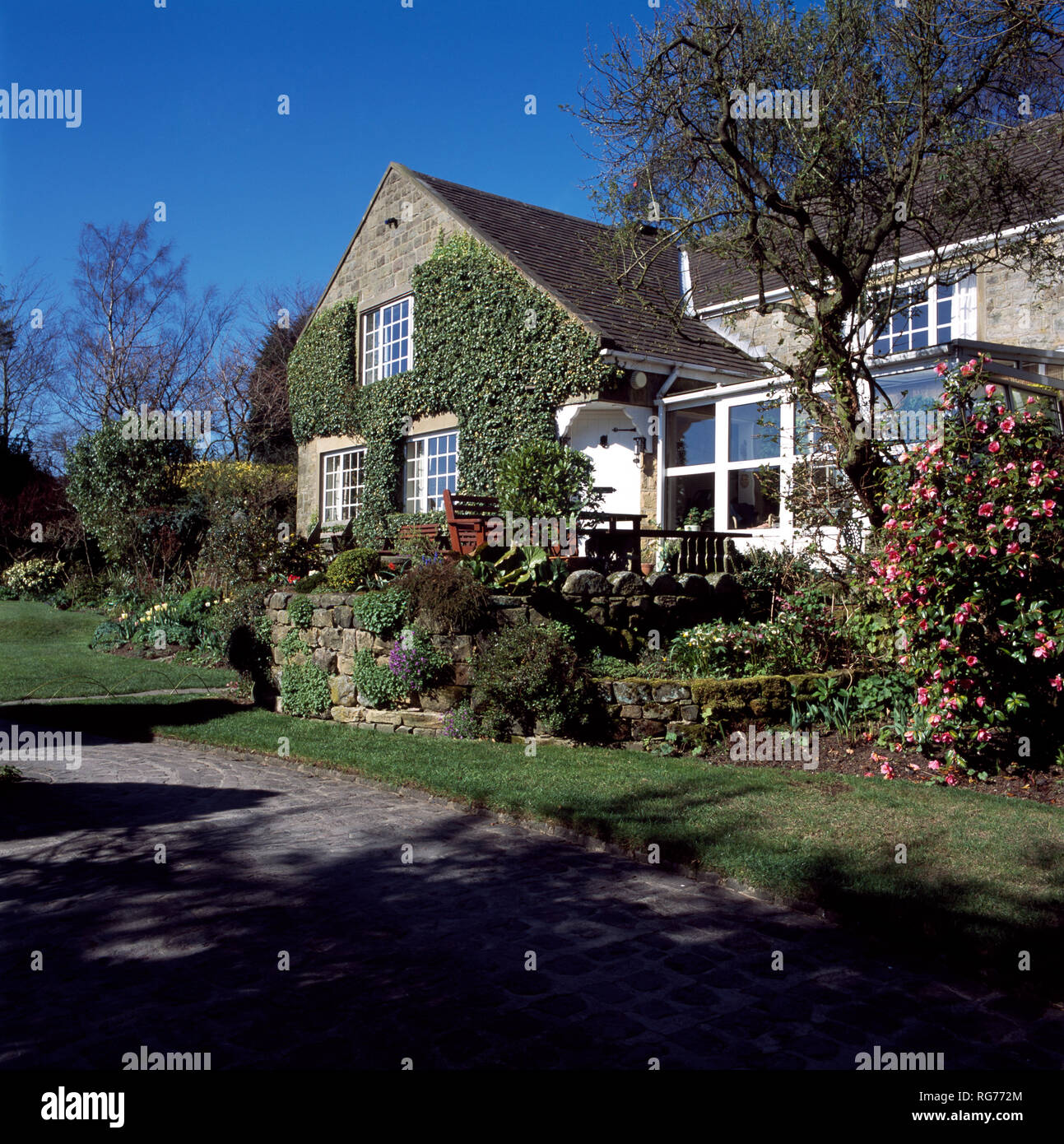 Exterior of house with glass conservatory extension and raised patio ...