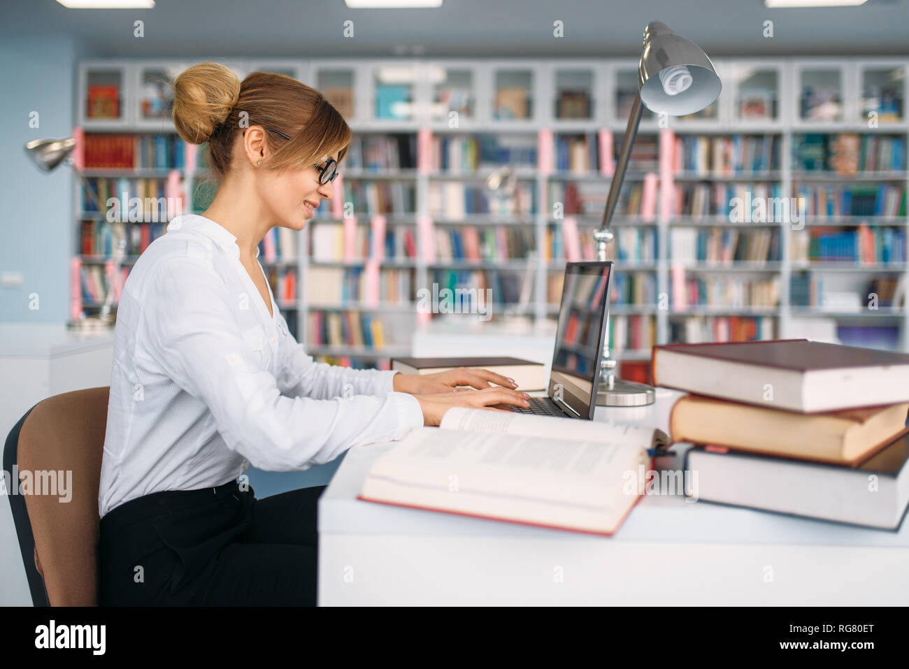 Female student at the laptop in university library. Young woman in ...