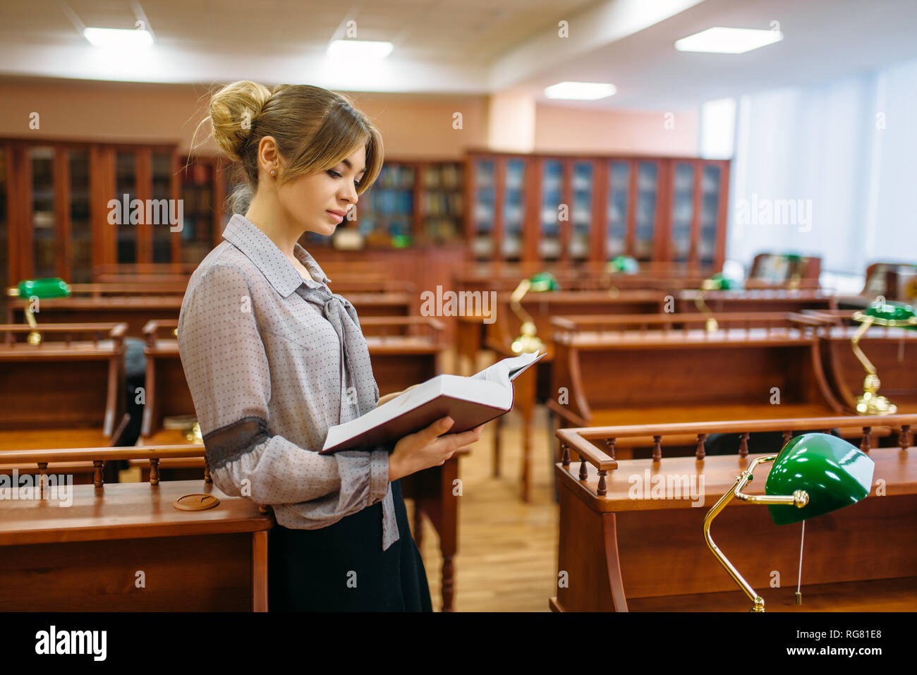 Pretty young woman in reading room, university library. Female person ...