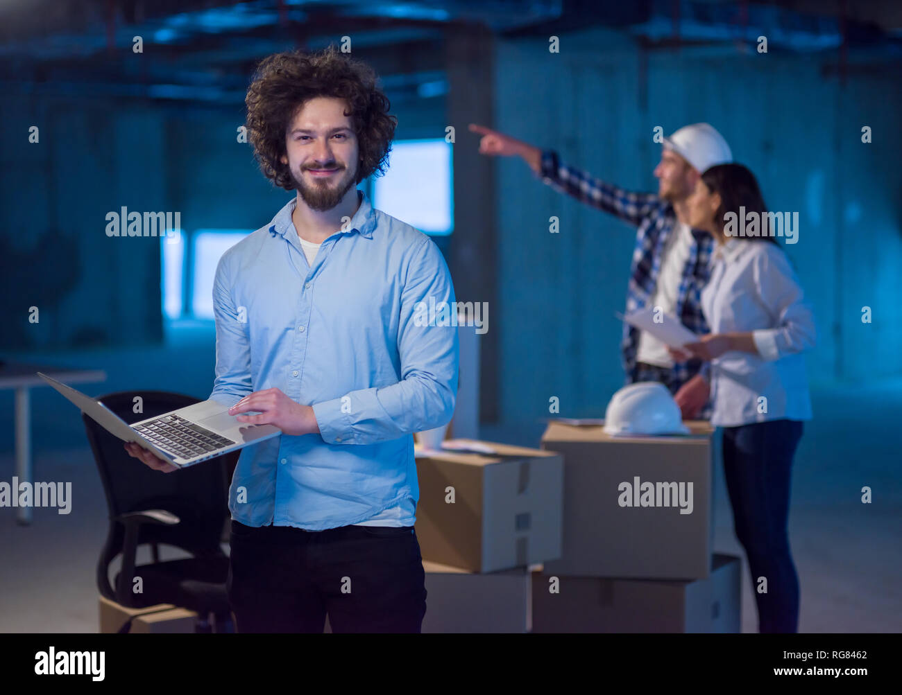 young male architect on construction site checking documents and ...