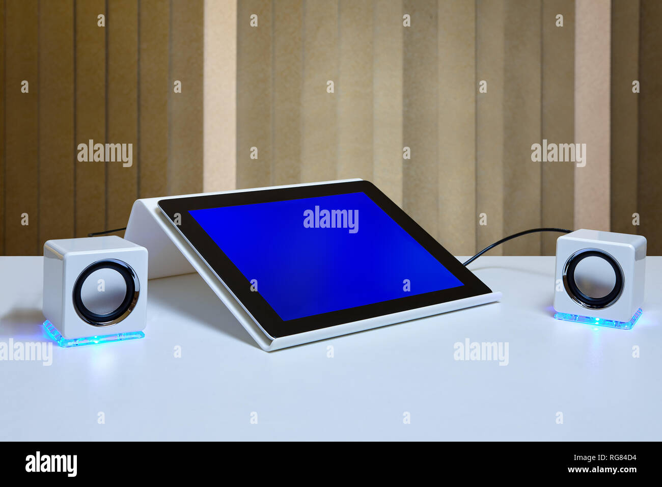 The tablet is mounted in a holder and connected to small speakers with ...