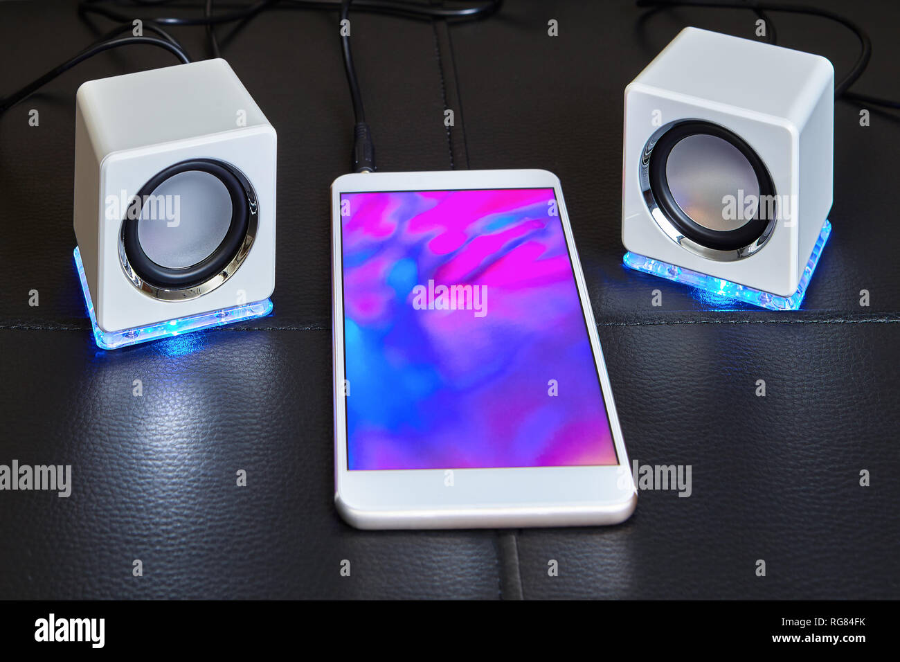 USB led speakers are connected to a smartphone with a bright display ...