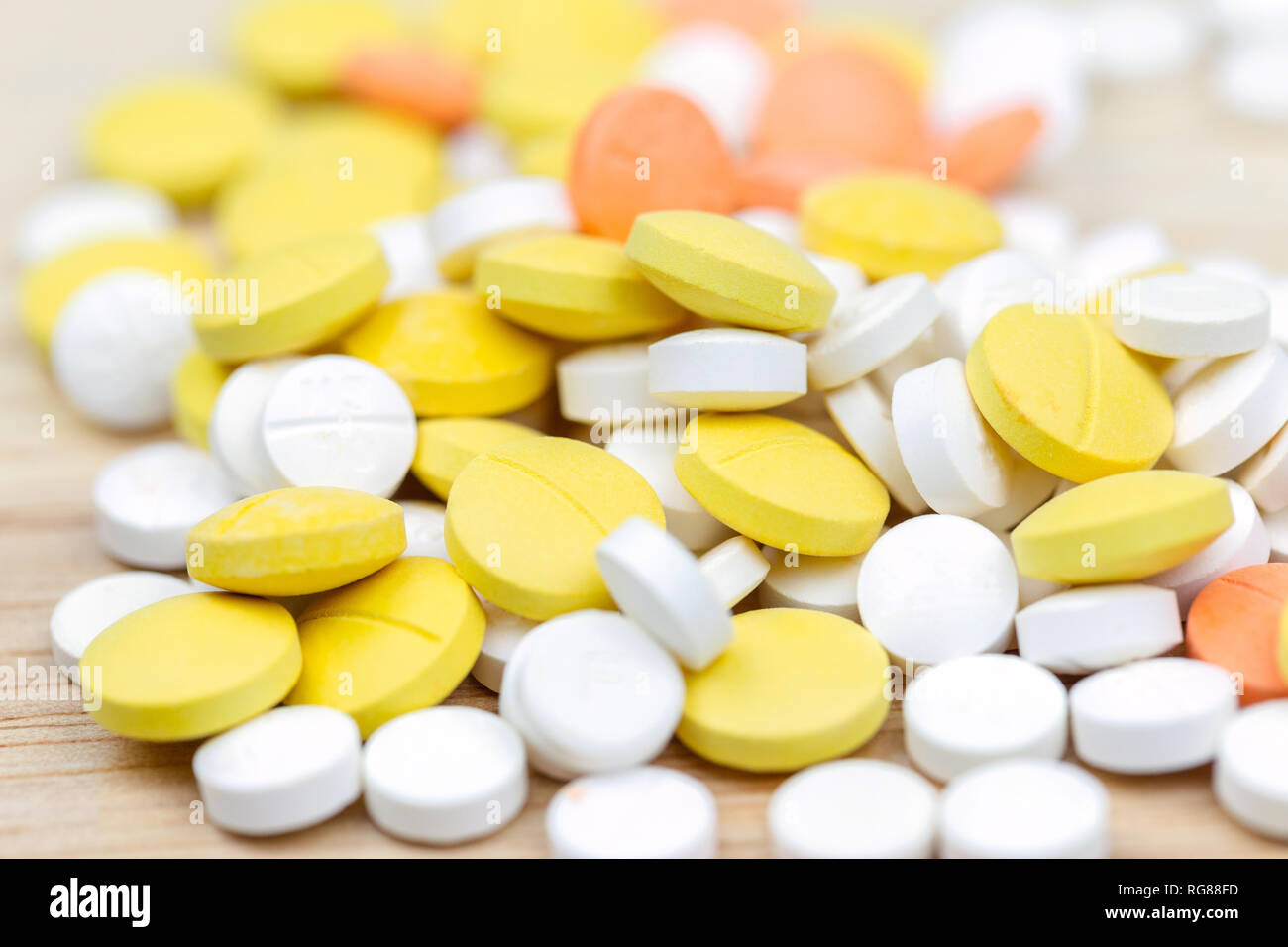Colorful medicine pills tablets or drugs closeup on wood table ...