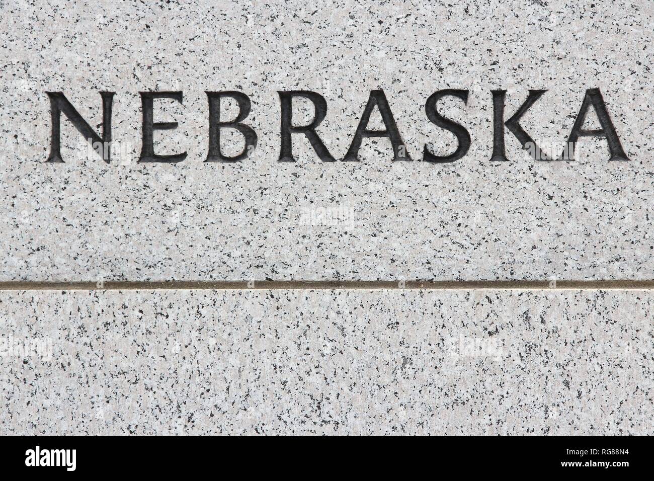 Nebraska - US state name carved in grey granite stone Stock Photo - Alamy